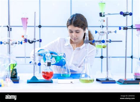 Young Adult Female Scientist Conducts A Chemical Experiment In A