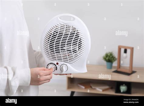 Woman Turning On Electric Fan Heater At Home Closeup Space For Text Stock Photo Alamy