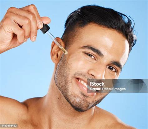 남자 얼굴 피부 세럼 또는 수염 오일의 얼굴 털 성장 미용 제품 행복한 젊은 아랍 남자 모델의 초상화 액체 피부과 및 바디 화장품을 위한 히알루론산 남자에 대한 스톡 사진