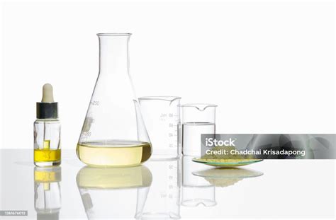 드롭퍼 병의 노란색 화장품 액체 에렌마이어 플라스크의 폴리 알루미늄 염화액 비커의 수정처럼 맑은 액체 실험실 테이블에 화학 시계 유리의 황화물 나트륨 플레이크 0명에 대한
