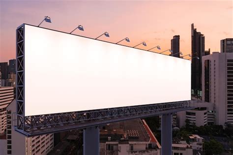 밤 시간에 방콕 도시 경관을 배경으로 하는 빈 흰색 도로 광고판 거리 광고 포스터는 3d 렌더링을 조롱합니다 프리미엄 사진