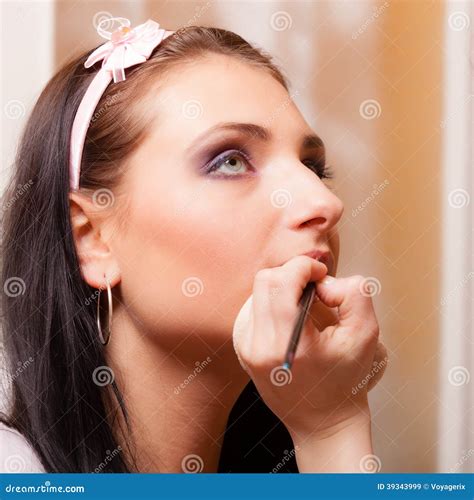 Makeup Artist Applying With Brush Lipstick On Lips Of Woman Stock Image