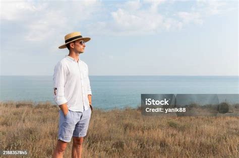 밀짚 모자를 쓴 반바지와 셔츠를 입은 해변 소년이 바다 배경 뒤에 서 있습니다 해안에서 혼자 휴가를 보내는 유대인 남자 관광에 대한 스톡 사진 및 기타 이미지 Istock