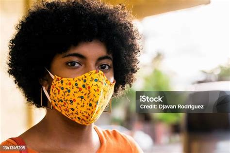 야외에서 다채로운 얼굴 마스크를 사용하는 아프로 여성 코로나 바이러스 보호 개념 복사 공간을 복사합니다 20 24세에 대한 스톡