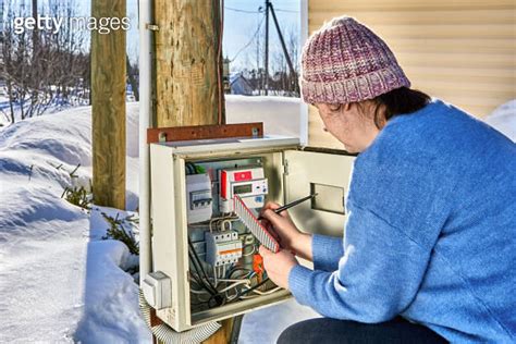 Taking Electric Meter Readings By Woman Outside In Village In Winter 이미지 1390346615 게티이미지뱅크