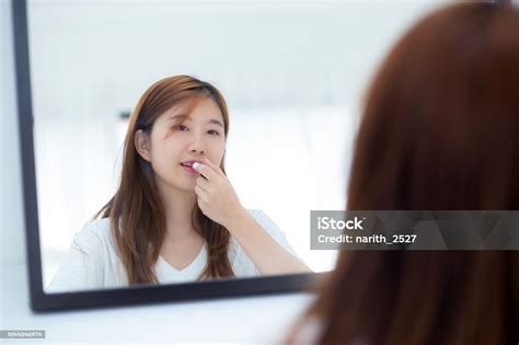 거울을 찾고 메이크업 립스틱 라이프 스타일 컨셉 룸에서 아름 다운 소녀 뷰티 패션에 젊은 아시아 여자의 초상화의 아름다움 가정의