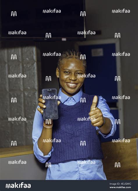 Une étudiante Souriante Montrant Un Portable Et Levant Le Pouce Makifaa