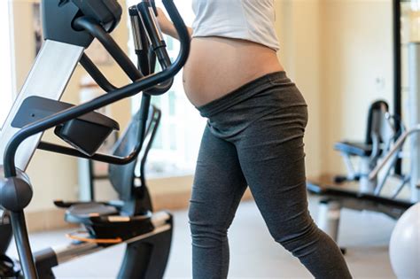 요가룸의 피트니스 센터에서 활동적인 임산부 운동을 합니다 임신 한 배에 아기를 들고 젊은 기대 어머니 출산 전 관리 및 여성 임신 개념 건강관리와 의술에 대한 스톡 사진 및