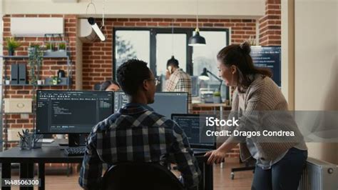 Ai 코드를 실행하는 여러 화면이 있는 책상에서 하이파이브 손 제스처를 하는 두 명의 소프트웨어 개발자 2명에 대한 스톡 사진