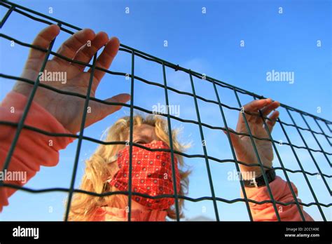 Blond Woman With An Alternative Mask Behind A Grid Stock Photo Alamy
