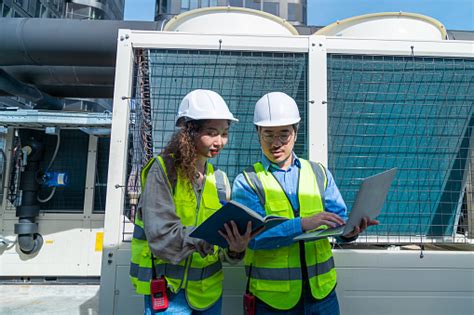 산업 냉수 팬 코일 단위 에어컨을 점검하는 엔지니어는 공기 시스템을 제어하는 대형 산업 건물의 물 냉각탑 공기 냉각기 Hvac 시스템입니다 20 24세에 대한 스톡 사진 및