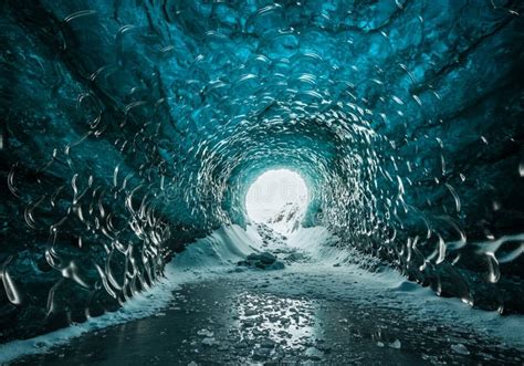 A Stunning Ice Cave Features A Smooth Translucent Blue Ceiling With