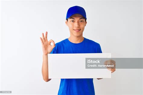 손가락으로 확인 기호를하고 고립 된 흰색 배경 위에 서 배너를 들고 모자를 입고 중국 배달원 우수한 기호 개념에 대한 스톡 사진 및 기타 이미지 Istock