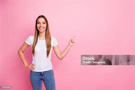 매력적인 긍정적 인 소녀 프로모터 포인트 집게 손가락 카피 스페이스의 초상화는 프로모션 광고가 분홍색 색상 배경 위에 고립 된