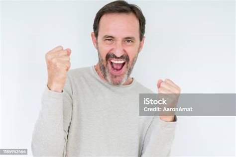 고립 된 배경을 통해 우아한 노인은 매우 행복하고 성공을 위해 미소와 비명을 지르는 팔을 들고 우승자 제스처를하고 흥분 축 하 개념입니다 긍정적인 감정 표현에 대한 스톡