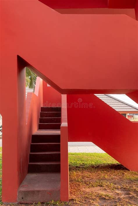 A Vibrant Red Architectural Structure Angular Walls And A Set Of