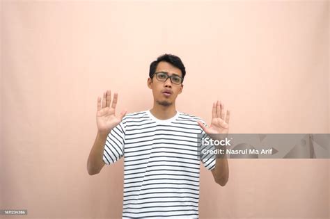 캐주얼한 줄무늬 티셔츠를 입고 안경을 쓴 아시아 남자의 초상화 중지 교차 금지 표시 금지 거부 표시 베이지색 배경입니다 30 34세에 대한 스톡 사진 및 기타 이미지