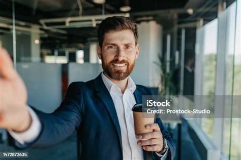 화상 통화를 하고 커피를 마시고 현대적인 사무실에 서서 카메라를 향해 웃고 있는 행복한 사업가 30 39세에 대한 스톡 사진 및 기타 이미지 Istock