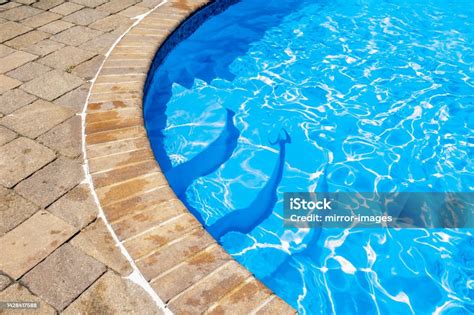 실내 또는 실외의 벽돌 플랫폼에서 물 속으로 들어가는 계단이있는 푸른 물 인 수영장 수영장 스포츠 경기장에 대한 스톡 사진 및