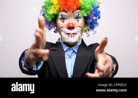 Clown Woman In Business Suit And Colorful Wig Making Gun Signs From