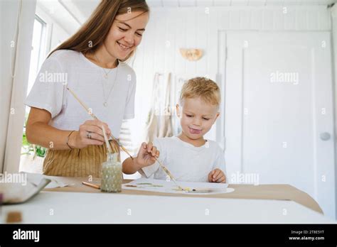 Mom Draws With Her Son Boy Tries He Sticks Out His Tongue Stock Photo Alamy