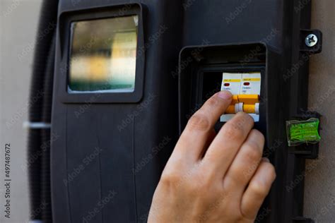 Electric Meter A Woman S Hand Turns On A Toggle Switch On An Electric Meter An Electricity