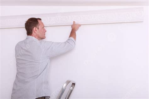 Man Installing A Protection On A Wall Photo Background And Picture For