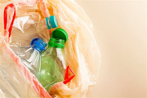 빈 플라스틱 물병을 분쇄 하 고 정리 및 복사 공간 산호 분홍색 배경 상단 보기에 재활용 쓰레기 가방에 구겨진 사용 플라스틱 무료 가정용 쓰레기 재활용 0명에 대한 스톡