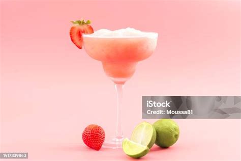 혼합 칵테일 파티 펀치 스무디 및 냉동 여름 음료 컨셉으로 딸기 모히토 또는 다이키리를 마가리타 안경에 넣고 딸기와 라임은 분홍색 배경에 고립되어 있습니다 칵테일에 대한