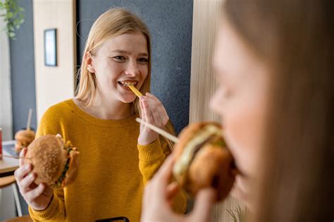 패스트푸드 레스토랑에서 감자 튀김과 햄버거를 먹는 두 명의 젊은 여성 먹기에 대한 스톡 사진 및 기타 이미지 먹기 프렌치 프라이 우정 Istock