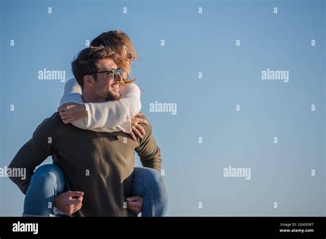 Men Giving Piggy Back Rides To His Girlfriend At Sunset By The Sea