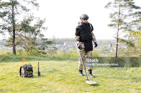 군복과 방탄 조끼를 입은 남자가 금속 탐지기로 숲에서 일합니다 지뢰 찾기는 영토를 제거하는 작업을 수행합니다 35 39세에 대한 스톡 사진 및 기타 이미지 Istock