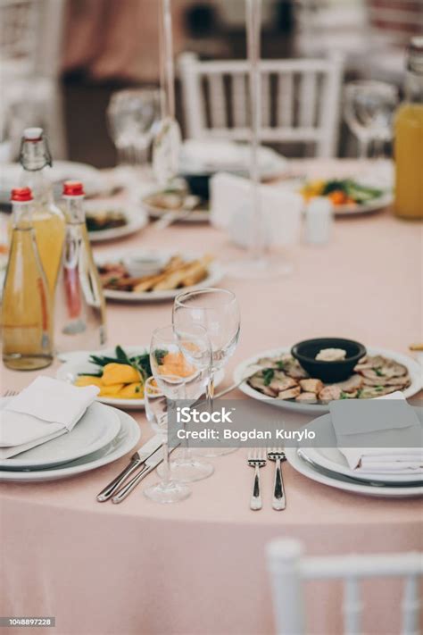 세련 된 웨딩 설정 와인잔 칼 붙이 냅킨 및 맛 있는 음식과 음료와 함께 부드러운 분홍색 테이블 식당에서 캐 더 링 한 럭셔리 현대 결혼식 피로연 0명에 대한 스톡 사진 및