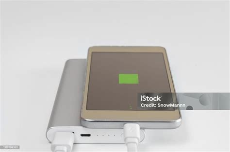 흰색 배경의 전원 뱅크에서 스마트폰 배터리 충전을 재충전하는 신호와 함께 표시합니다 여행 용 충전 장치를위한 외부 용적 Usb 케이블에 대한 스톡 사진 및 기타 이미지