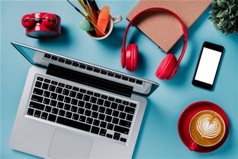 محل کار در خانه با میز چوبی نمای بالای لپ تاپ با نوت بوک و قهوه از بالا