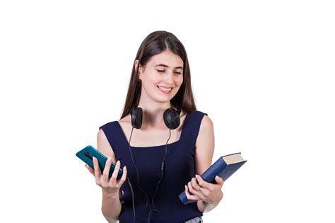 흰색 배경에 고립된 책과 전화기를 손에 들고 목에 헤드셋을 두른 즐거운 학생 소녀 책에 대한 스톡 사진 및 기타 이미지 책 헤드셋 청년 성인 Istock
