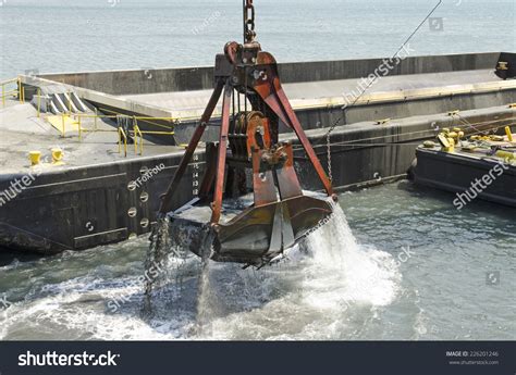A Cable Powered Crane Uses A Clam Shell Bucket To Remove Sand In A