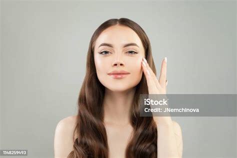 건강 한 곱슬 머리 깨끗 한 피부와 잘 손질 된 손톱과 손을 가진 젊은 완벽 한 여자의 초상화 건강관리와 의술에 대한 스톡 사진