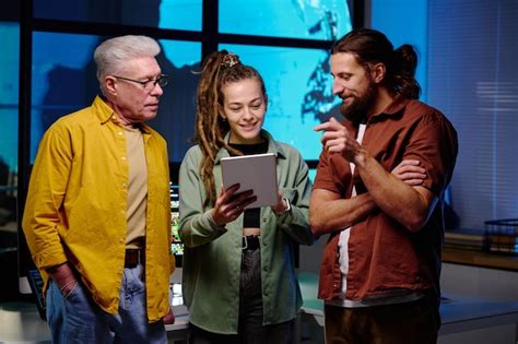 premium photo group of three programmers discussing points of