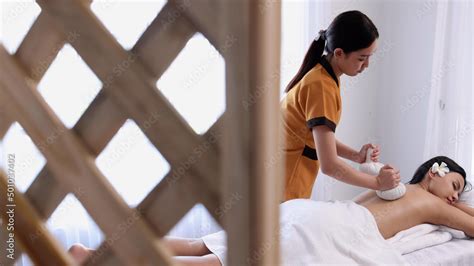 Young Asian Woman Receiving Back Massage With Thai Herbal Compress Ball