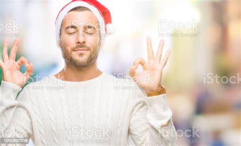 잘생긴 젊은이 모자 고립 된 배경 위에 휴식 하는 산타 클로스를 착용 하 고 눈으로 웃 고 손가락으로 명상 제스처를 하 고 폐쇄 요가 개념 공휴일에 대한 스톡 사진 및 기타