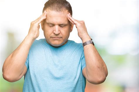 중세 아랍 남자에 파란색 티셔츠를 입고 머리에 통증에 대 한 머리에 손으로 배경 고립 때문에 스트레스 편두통 고통 T 셔츠에 대한 스톡 사진 및 기타 이미지 Istock