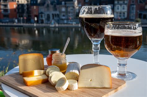 벨기에 수도원 맥주 한 잔과 트랩피스트 맥주로 만든 치즈와 벨기에 발로니아 주 디난트의 마스 강을 조망할 수 있는 고급 허브로 만든 치즈 시음 0명에 대한 스톡 사진 및