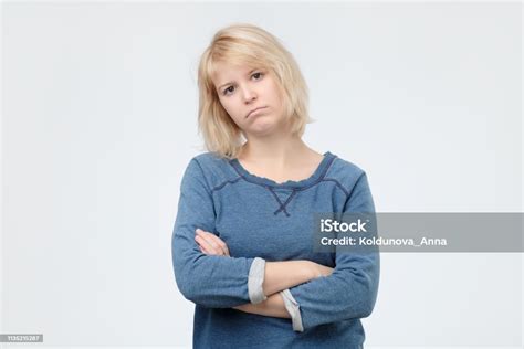 여 자가 그녀의 얼굴을 장난 치며 놀고 파란 긴 소매 스웨터를 입고 팔을 접어 유지 감정에 대한 스톡 사진 및 기타 이미지