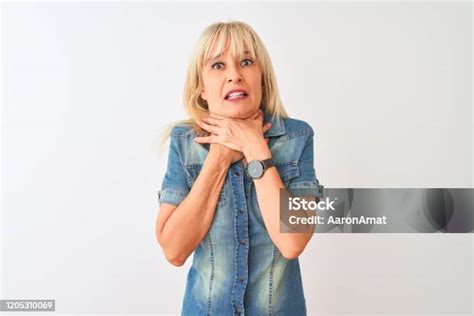 캐주얼 한 데님 셔츠를 입고 고립 된 흰색 배경 위에 서있는 중년 여성은 고통스러운 목졸림 때문에 외치고 질식합니다 건강 문제 질식 과 자살 개념 건강관리와 의술에 대한