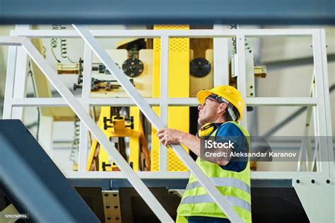 반사 조끼와 안전 헬멧을 착용하고 기계를 조정하는 공장에서 일하는 노동자의 초상화 45 49세에 대한 스톡 사진 및 기타 이미지 45 49세 건설 산업 건축 Istock