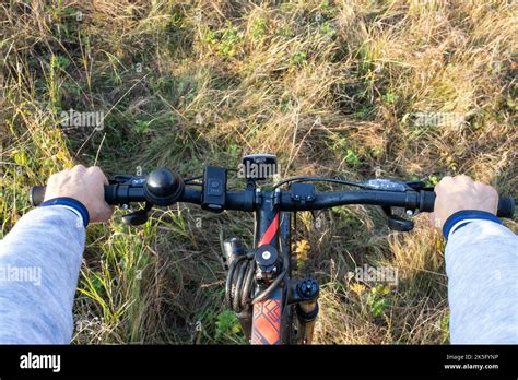 Person Riding A Bike A Man Holds The Handlebars Of A Bicycle On Grass Background On A Field