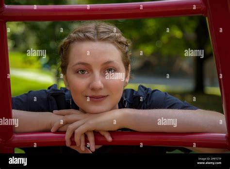Young Blonde Woman In Red Ladder At The Amusement Park Playground