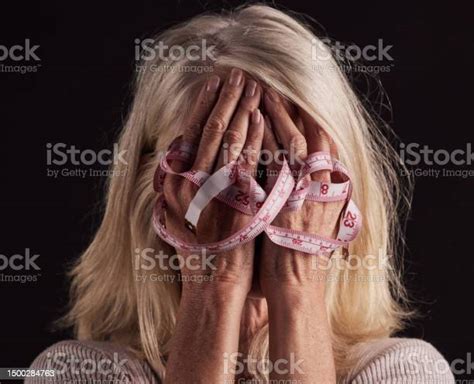 손 줄자 거식증은 슬픔에 잠긴 어두운 배경에 스튜디오에서 얼굴을 들고 있는 여성입니다 우울증 섭식 장애 및 폭식증은 건강에