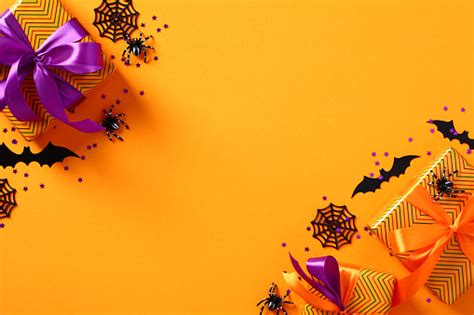 해피 할로윈 휴가 개념 할로윈 장식 선물 상자 거미 박쥐 오렌지 배경에 색종이가있는 평평한 누워 구성 복사 공간이 있는 위쪽